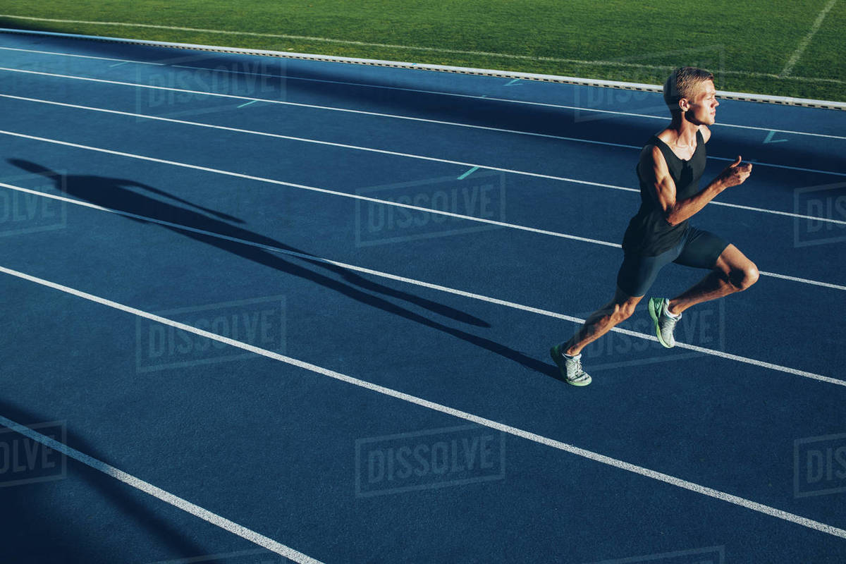 Shot of young professional sprinter running on racetrack. Runner ...