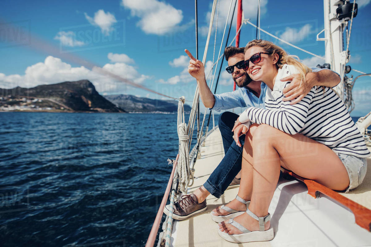 Happy young couple enjoying in summer day on yacht. Young man with his ...