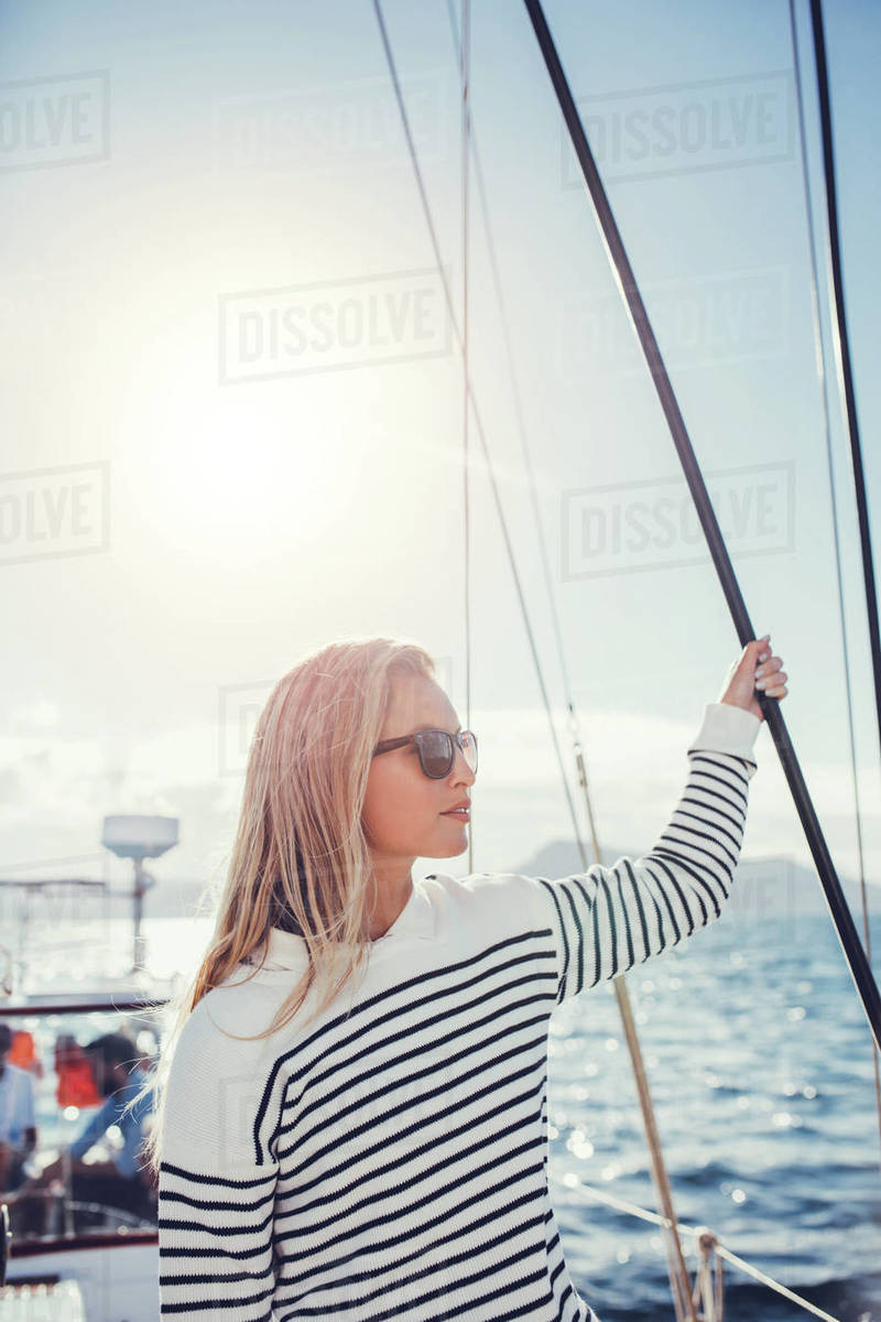 Portrait of attractive young woman standing on a yacht on summer day ...