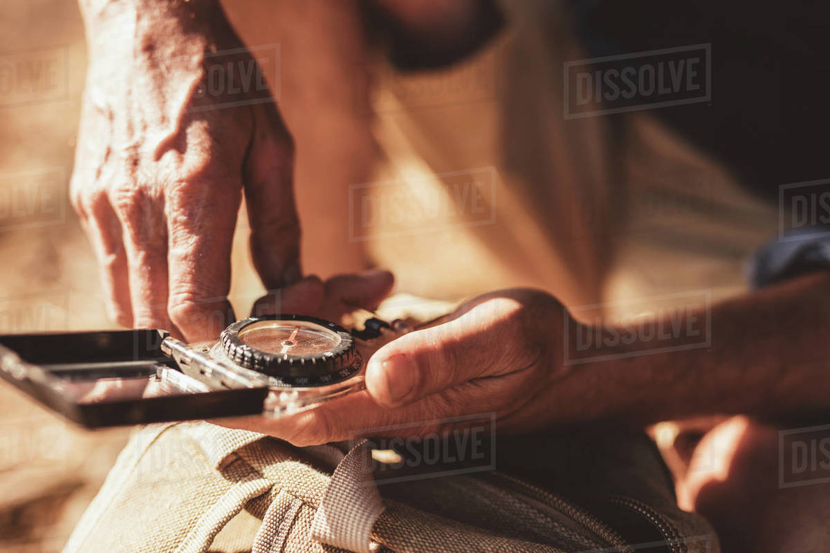 Close up portrait of man using compass for directions. Focus on compass ...