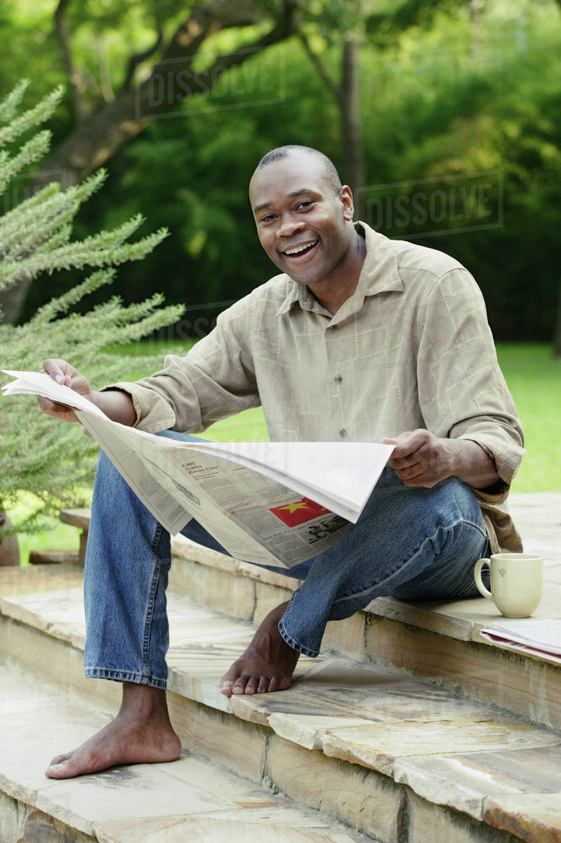 Man reading newspaper outdoors - Royalty-free Stock Photo | Dissolve