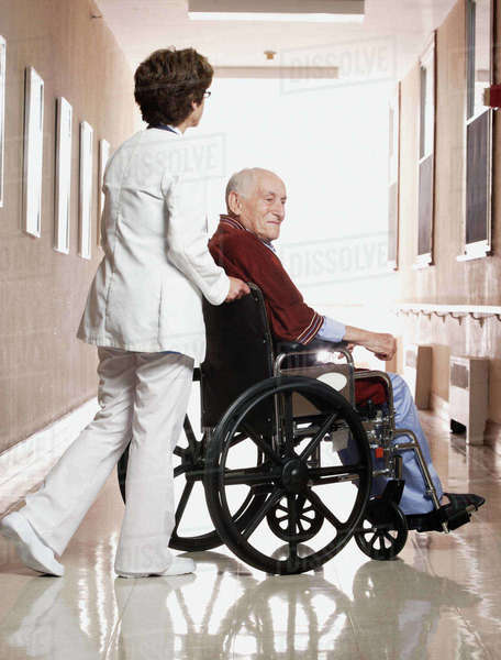 Nurse wheeling elderly man in wheelchair away - Royalty-free Stock ...