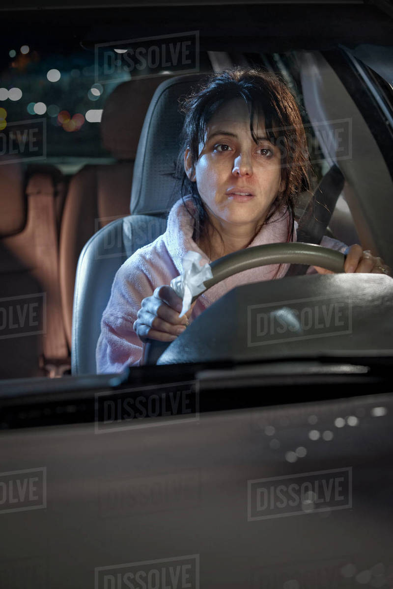 Sick woman driving car at night - Royalty-free Stock Photo | Dissolve