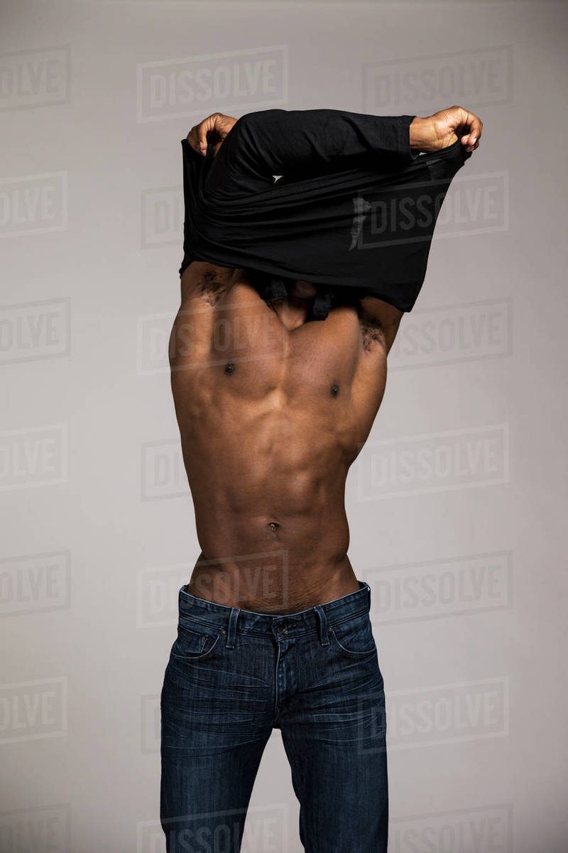 Man removing shirt - Royalty-free Stock Photo | Dissolve