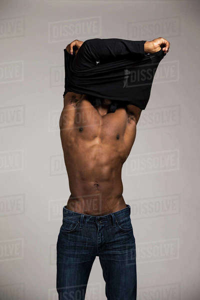 Man removing shirt - Royalty-free Stock Photo | Dissolve