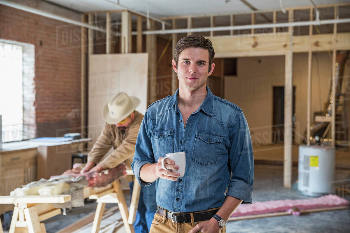 Man drinking coffee at construction site - Stock Photo - Dissolve