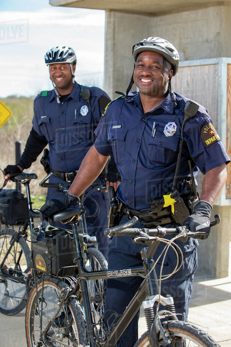 Portrait of Bicycle Police officers standing outside with their bikes ...