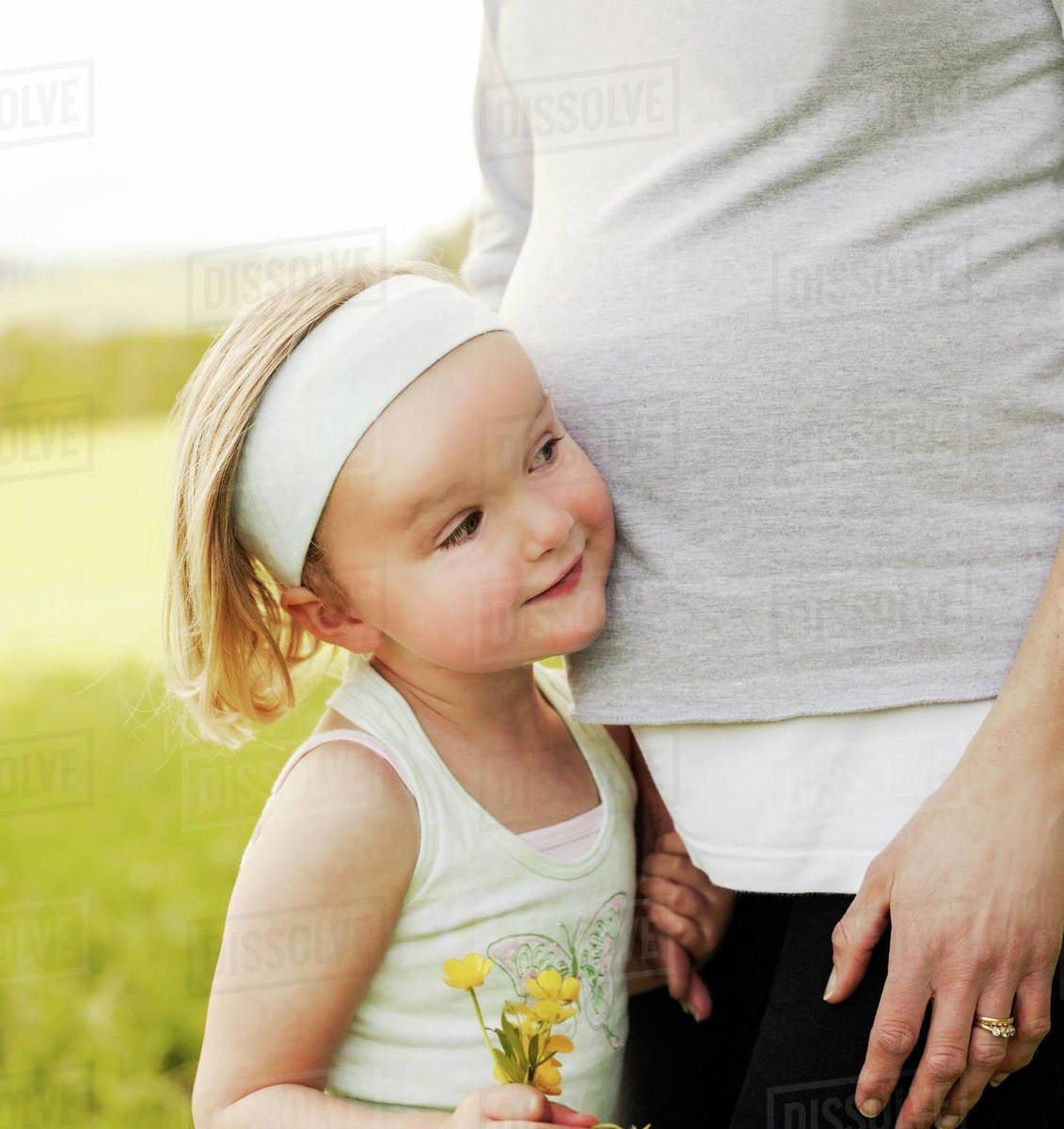 Little girl holding a handful of buttercups and resting her head on ...