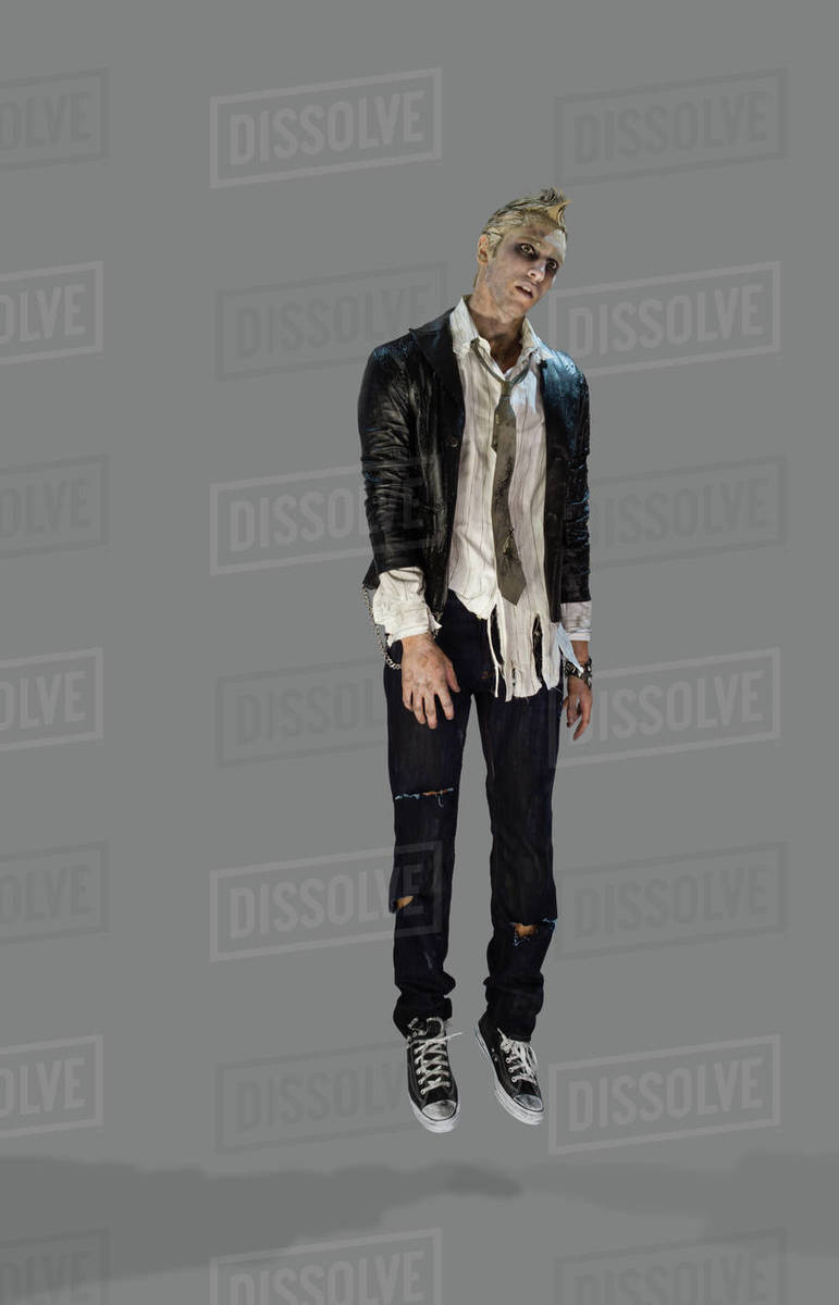 Man dressed up as a zombie hanging mid air looking towards camera with ...