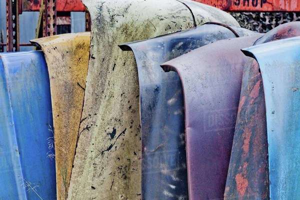 Stacked car hoods in wrecking yard - Stock Photo - Dissolve