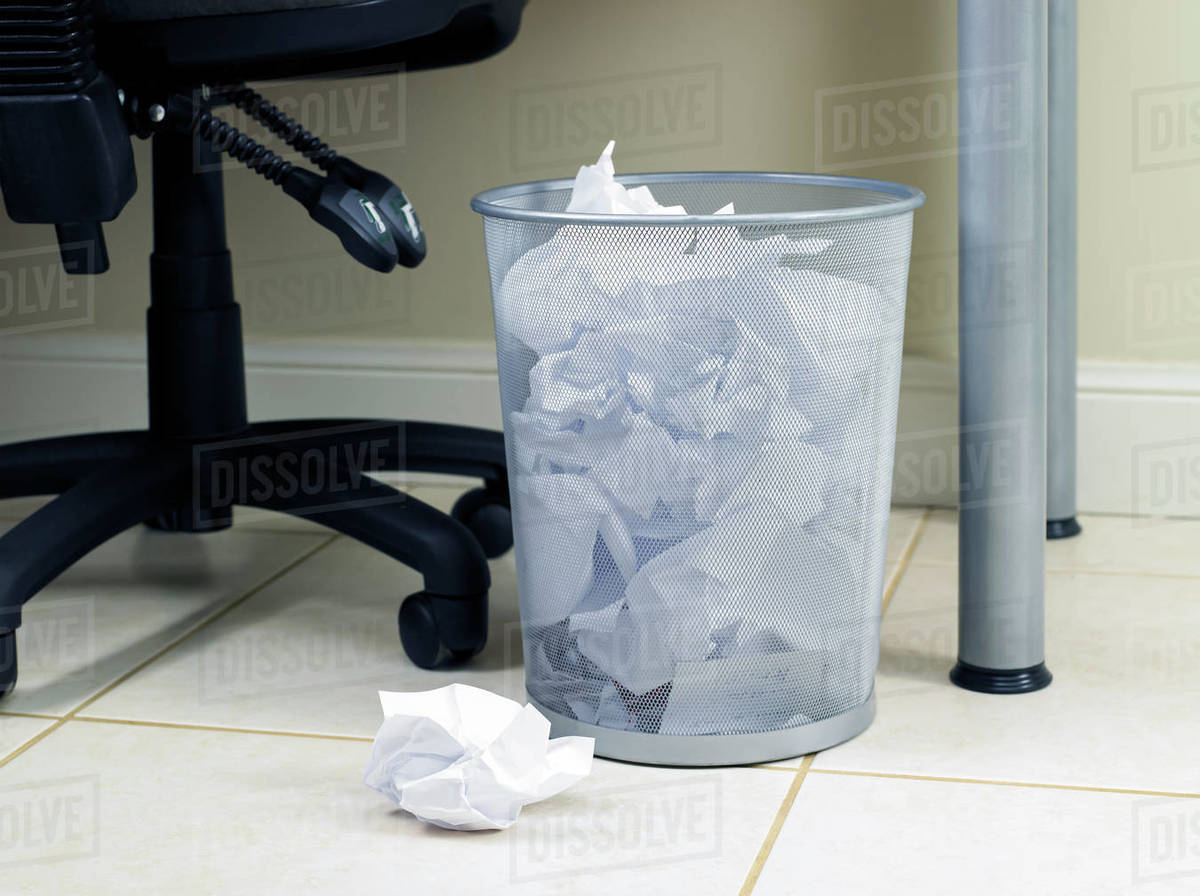 Rubbish bin full of crumpled paper under desk - Royalty-free Stock ...