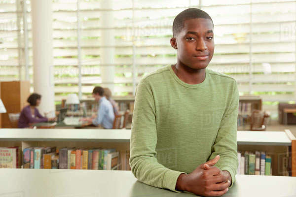 Portrait of Black student in library looking at camera with confidence ...