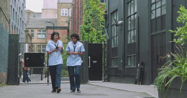 Two nurses in scrubs walk outside together - 4K Royalty-free Stock ...