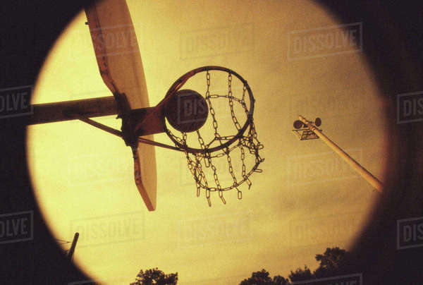 Basketball falling through a hoop - Stock Photo - Dissolve