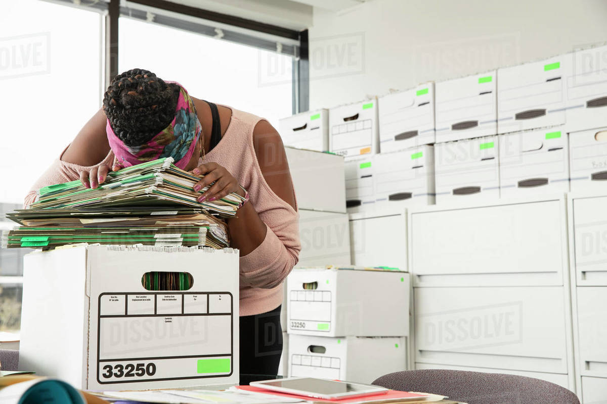 A woman laying her head down on top of a stack of files - Royalty-free ...