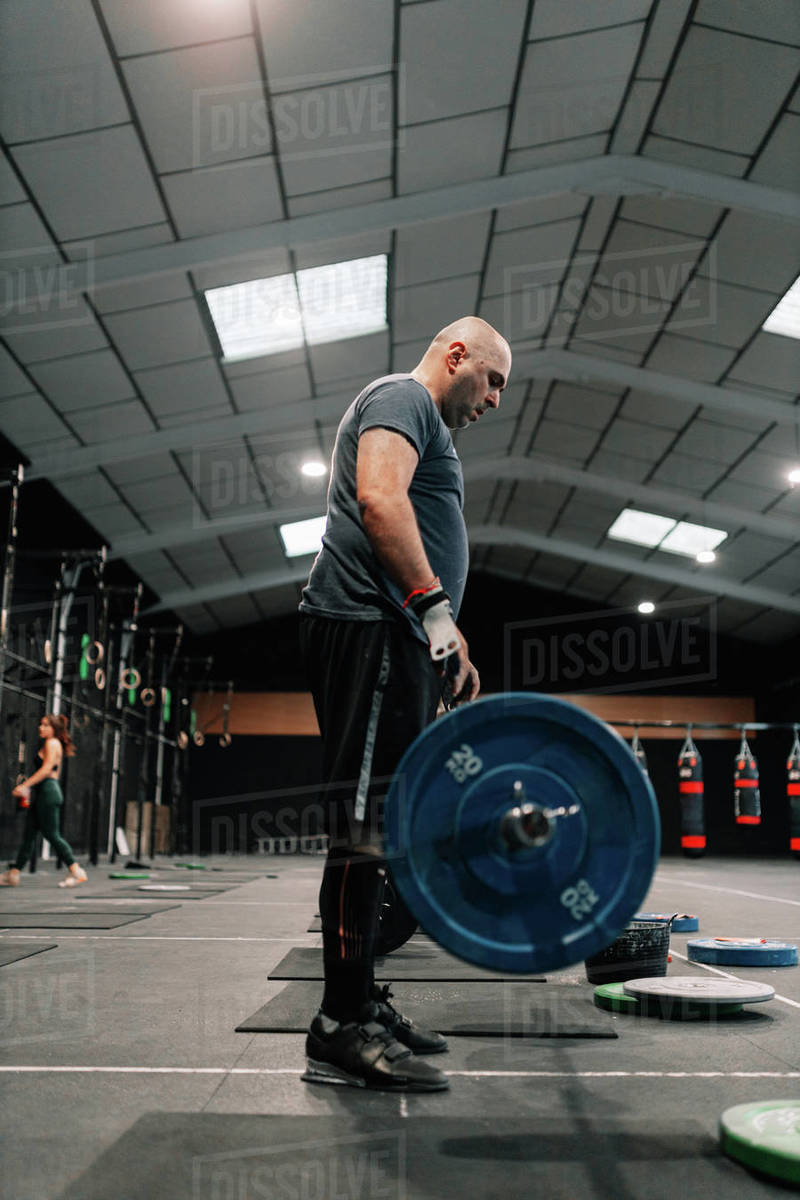 Adult bald man weightlifter exercising in gym - Royalty-free Stock ...