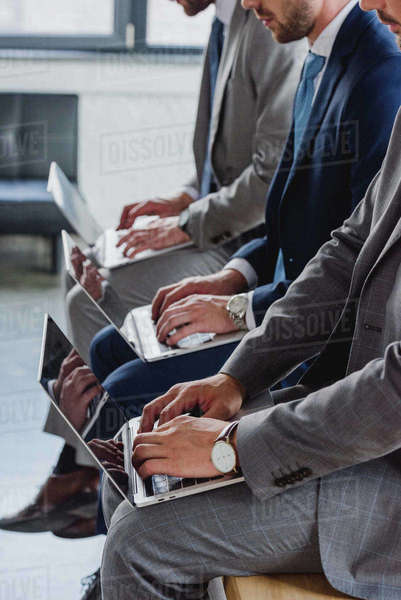 Cropped shot of young businessmen in formal wear using laptops - Stock ...