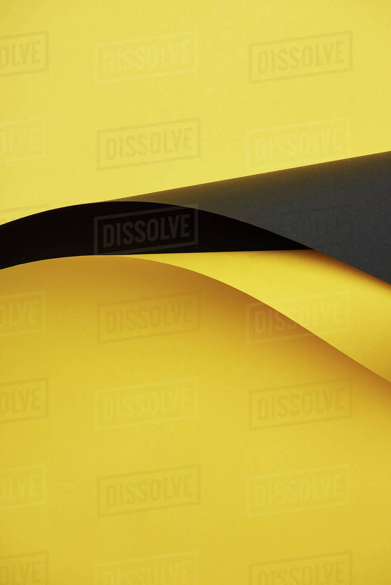 Close-up view of beautiful bright yellow and black paper background ...