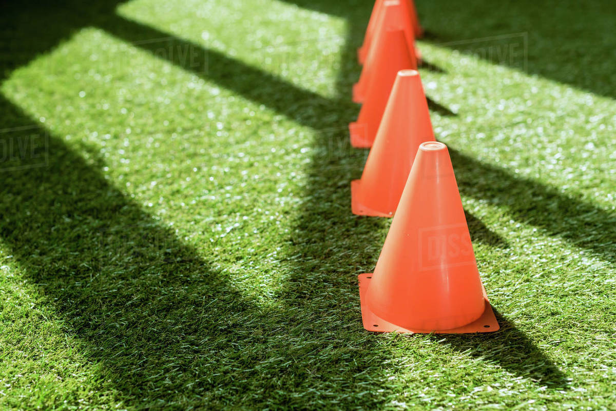 close-up shot of row of safety cones standing on green grass - Stock ...