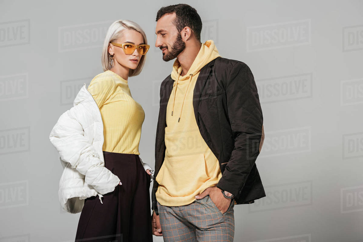 stylish couple of models in autumn outfits posing isolated on grey ...