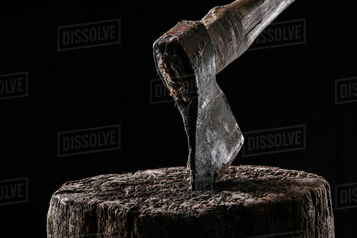 Close up view of vintage axe on wooden stump isolated on black ...