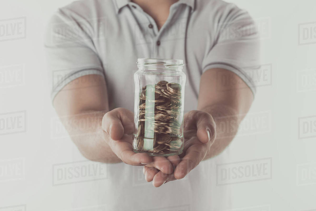 Cropped image of man showing jar of coins in hands isolated on white ...