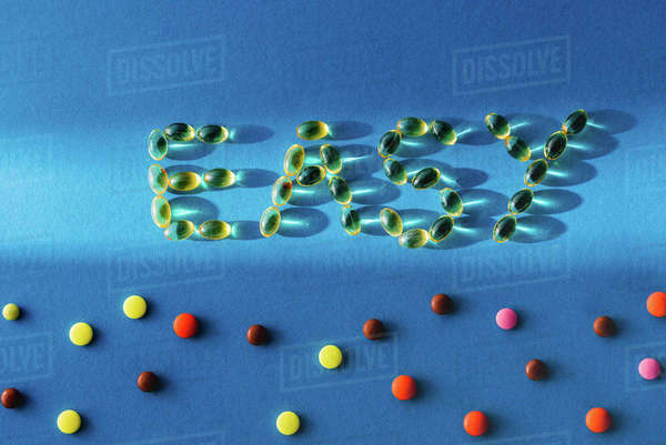top view of lettering easy by pills near various tablets on blue ...