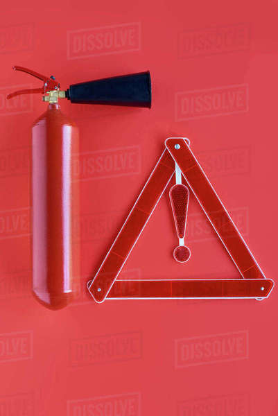 top view of fire extinguisher and warning triangle isolated on red ...