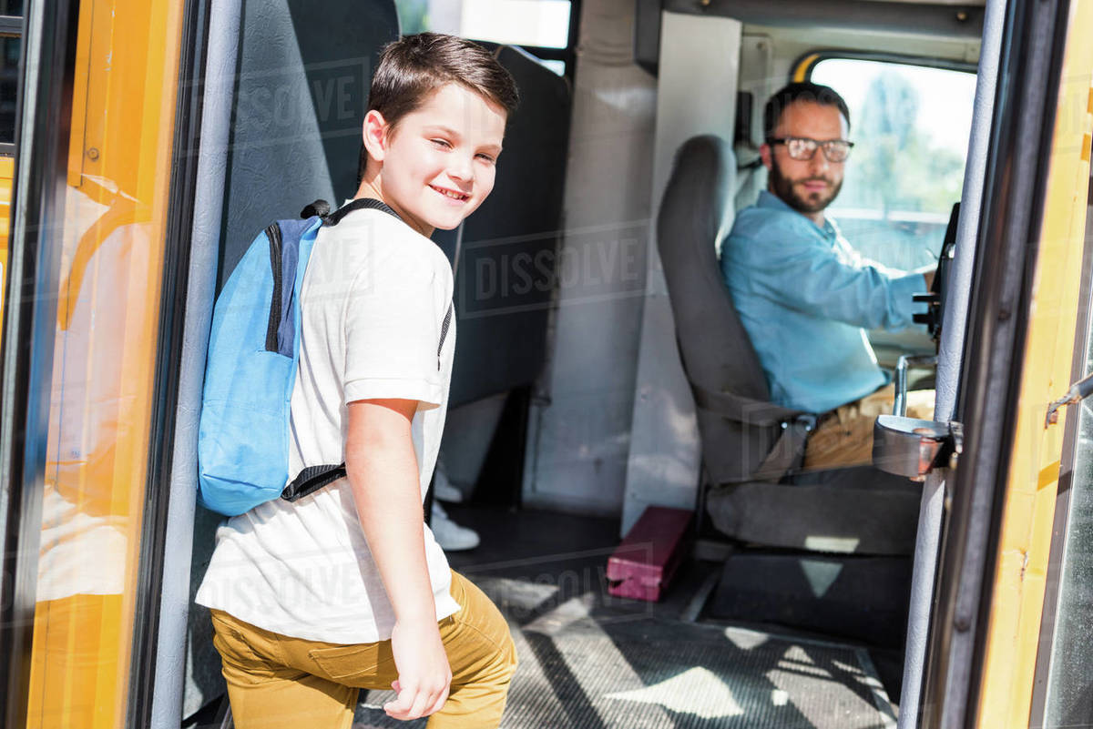 handsome school bus driver and schoolboy looking at camera - Royalty ...