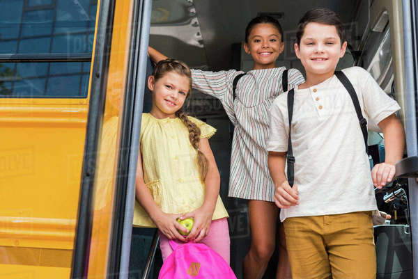 group of adorable pupils standing at school bus - Royalty-free Stock ...