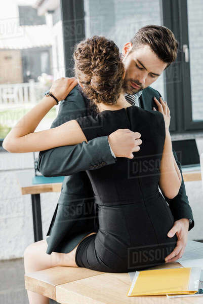 passionate businessman unzipping dress of seductive businesswoman at ...
