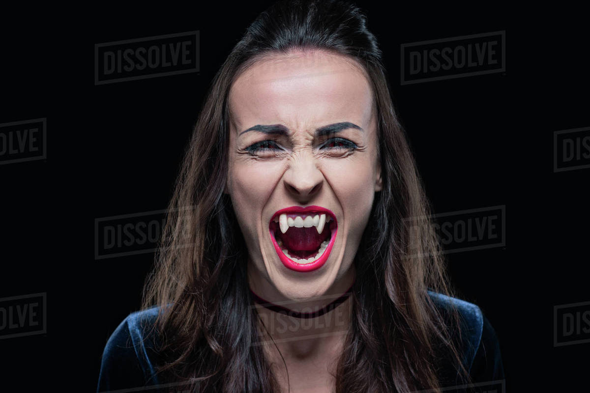 Gothic woman showing vampire teeth isolated on black - Stock Photo ...