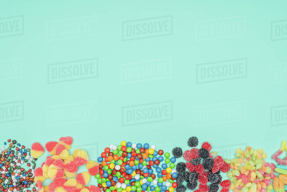 Top view of different colored sweets isolated on turquoise - Stock ...