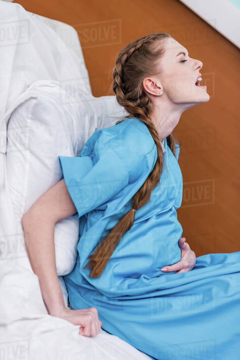 Side view of pregnant woman giving birth in hospital - Stock Photo ...