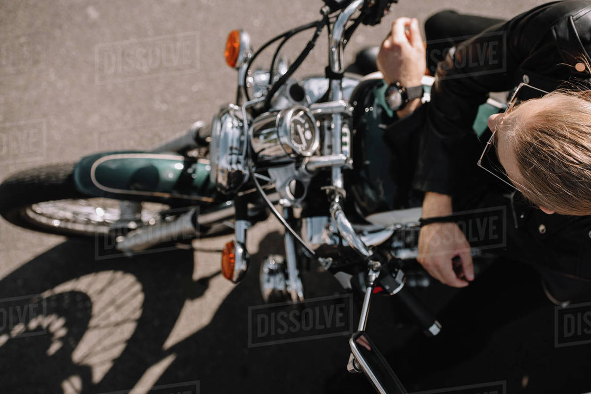 Overhead view of biker sitting on vintage classical motorcycle ...