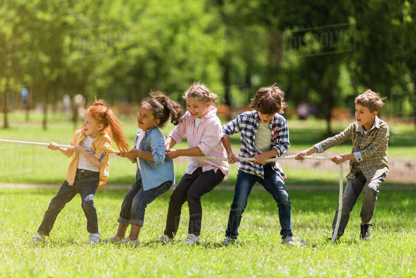 side view of adorable multiethnic kids pulling rope in park - Royalty ...