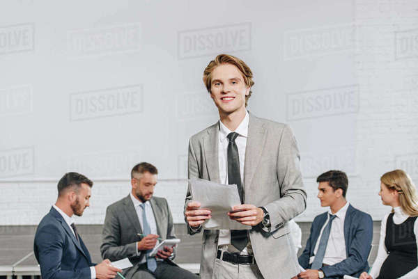 business coach standing in front of businesspeople at training in hub ...