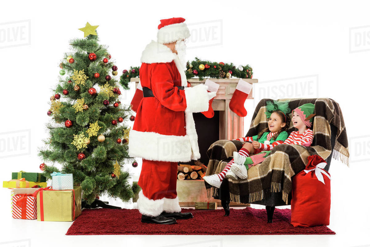 Santa talking to kids while they sitting in his armchair isolated on ...