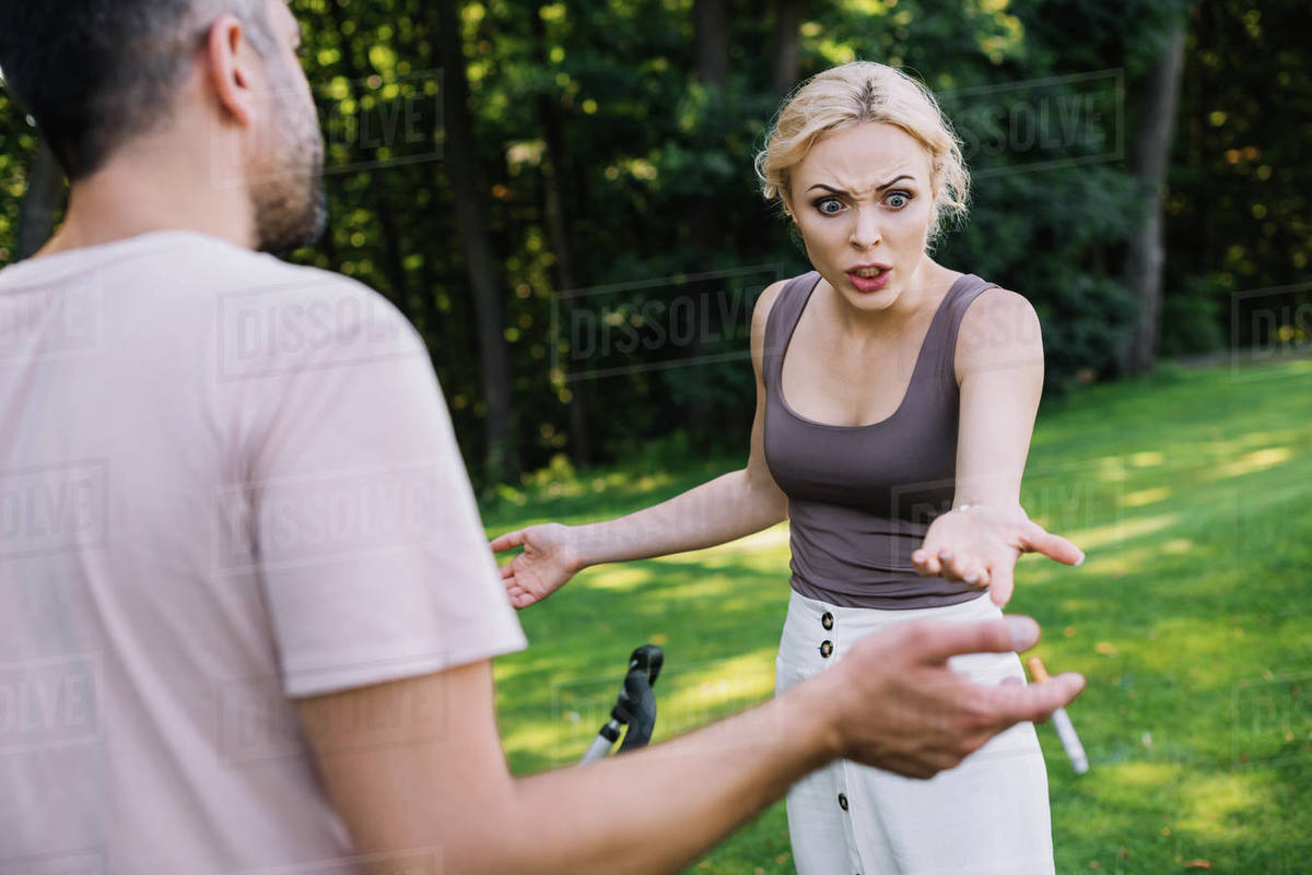 Father smoking cigarette near baby carriage in park, mother screaming ...