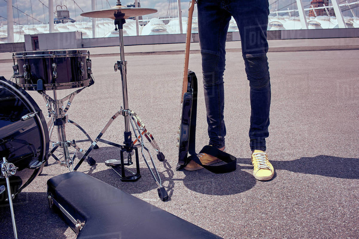 Partial view of musician standing near musical instruments on street ...