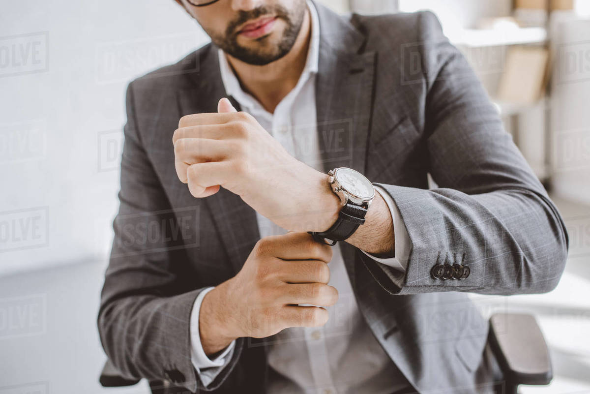 Cropped image of businessman wearing wristwatch in office - Stock Photo ...