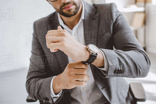 Cropped image of businessman wearing wristwatch in office - Stock Photo ...