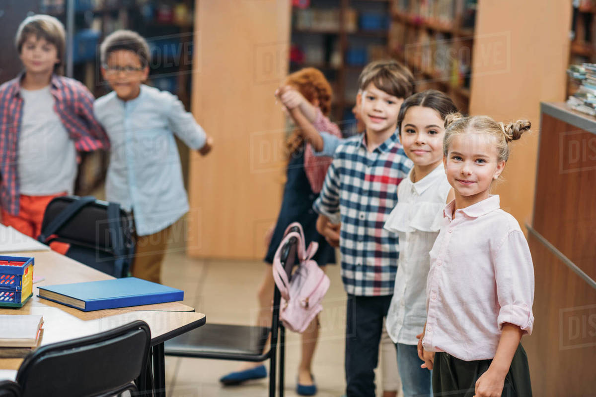 adorable little kids standing in row in library - Stock Photo - Dissolve