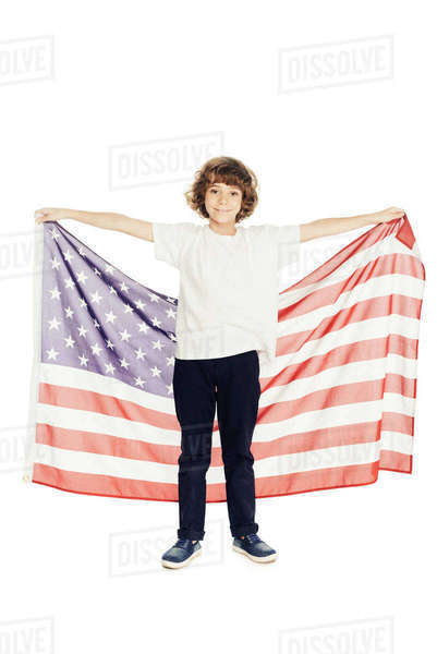 Adorable preteen boy holding American flag and looking at camera ...