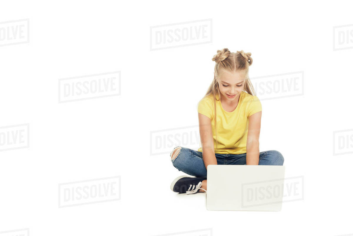 Beautiful smiling child sitting and using laptop isolated on white ...