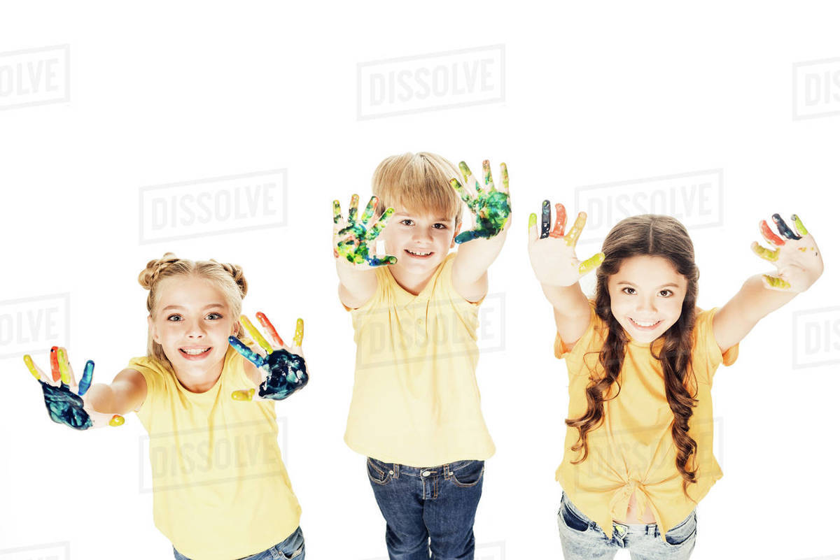 High angle view of happy kids showing hands in paint and smiling at ...