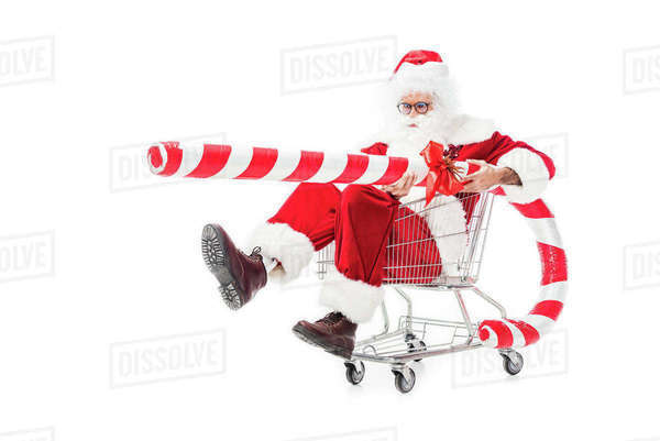 Santa Claus holding big striped Christmas stick in trolley isolated on ...