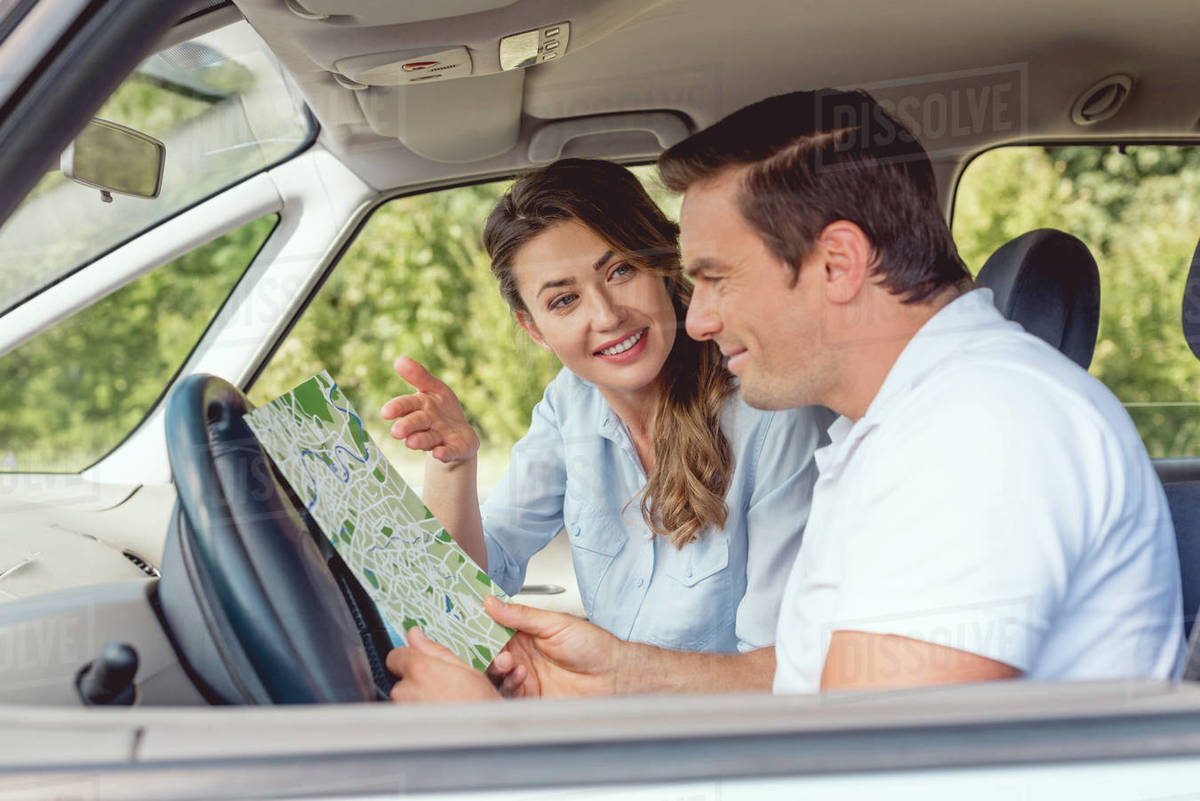 happy adult couple navigating with map during car trip - Royalty-free ...