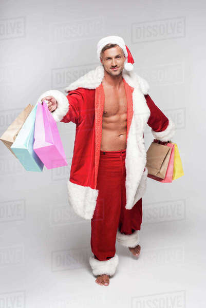 High angle view of handsome barefoot man in santa costume holding ...