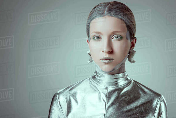 Futuristic silver female robot looking at camera isolated on grey ...